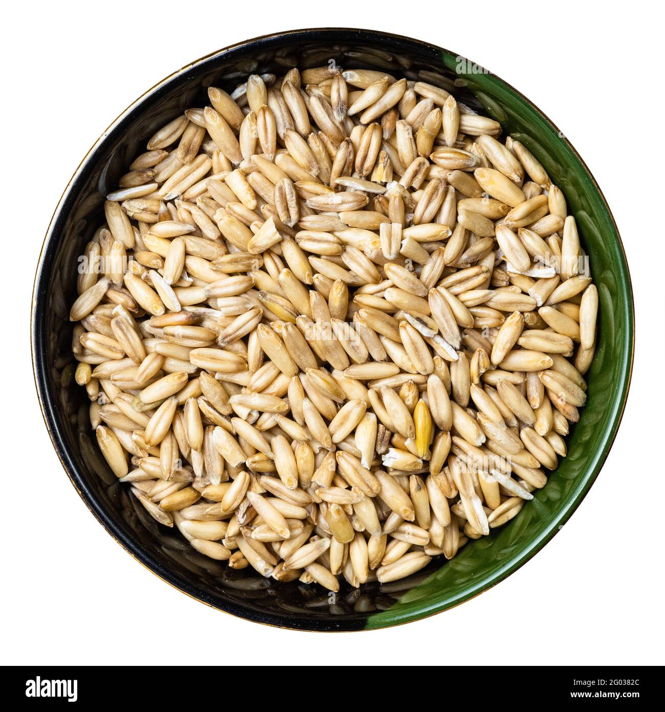 top view of unpolished oat grains in round bowl isolated on white ...