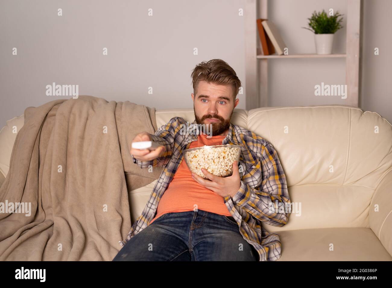 Single man on the couch watching TV Stock Photo - Alamy