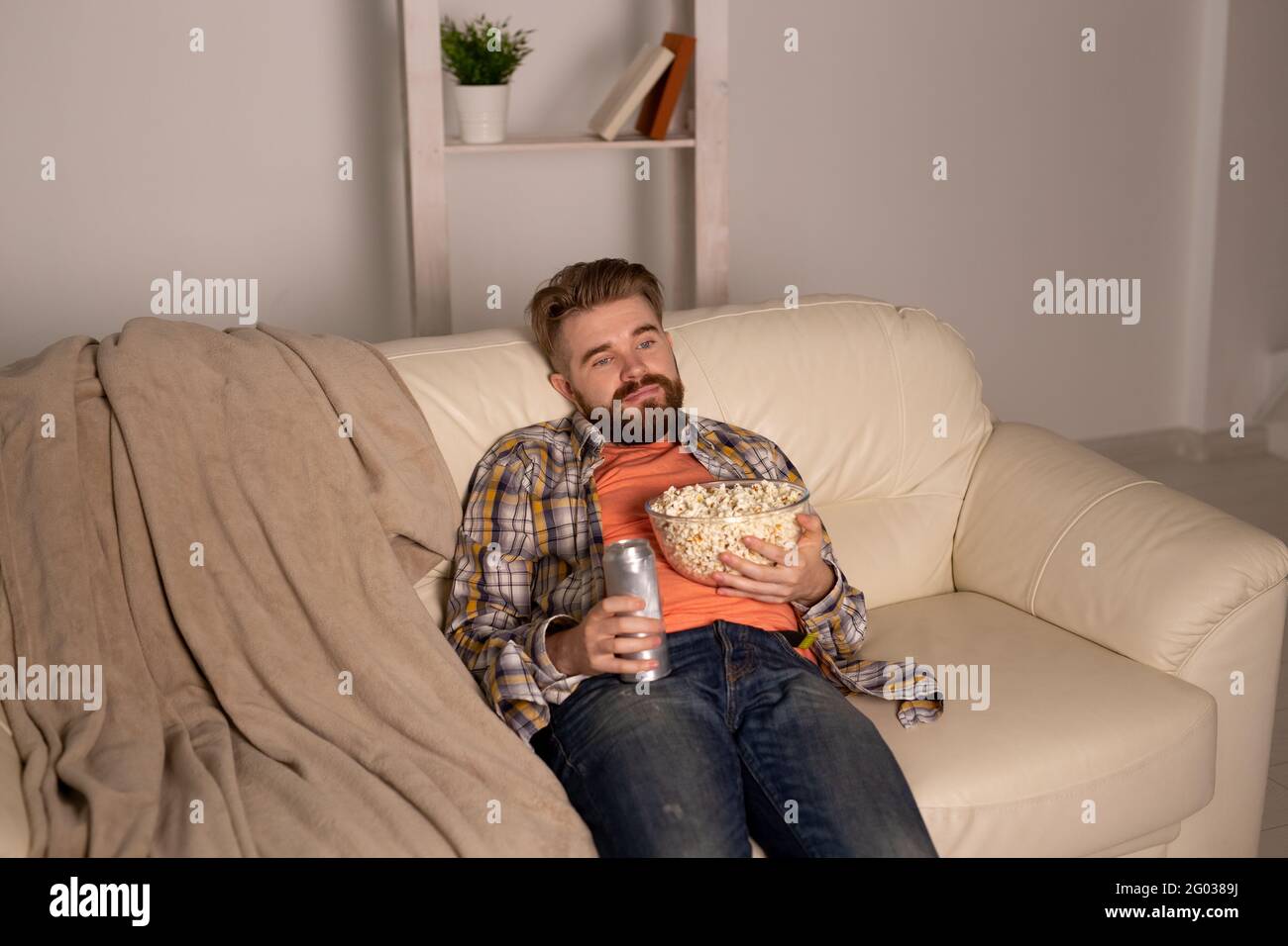 Single man on the couch watching TV Stock Photo - Alamy