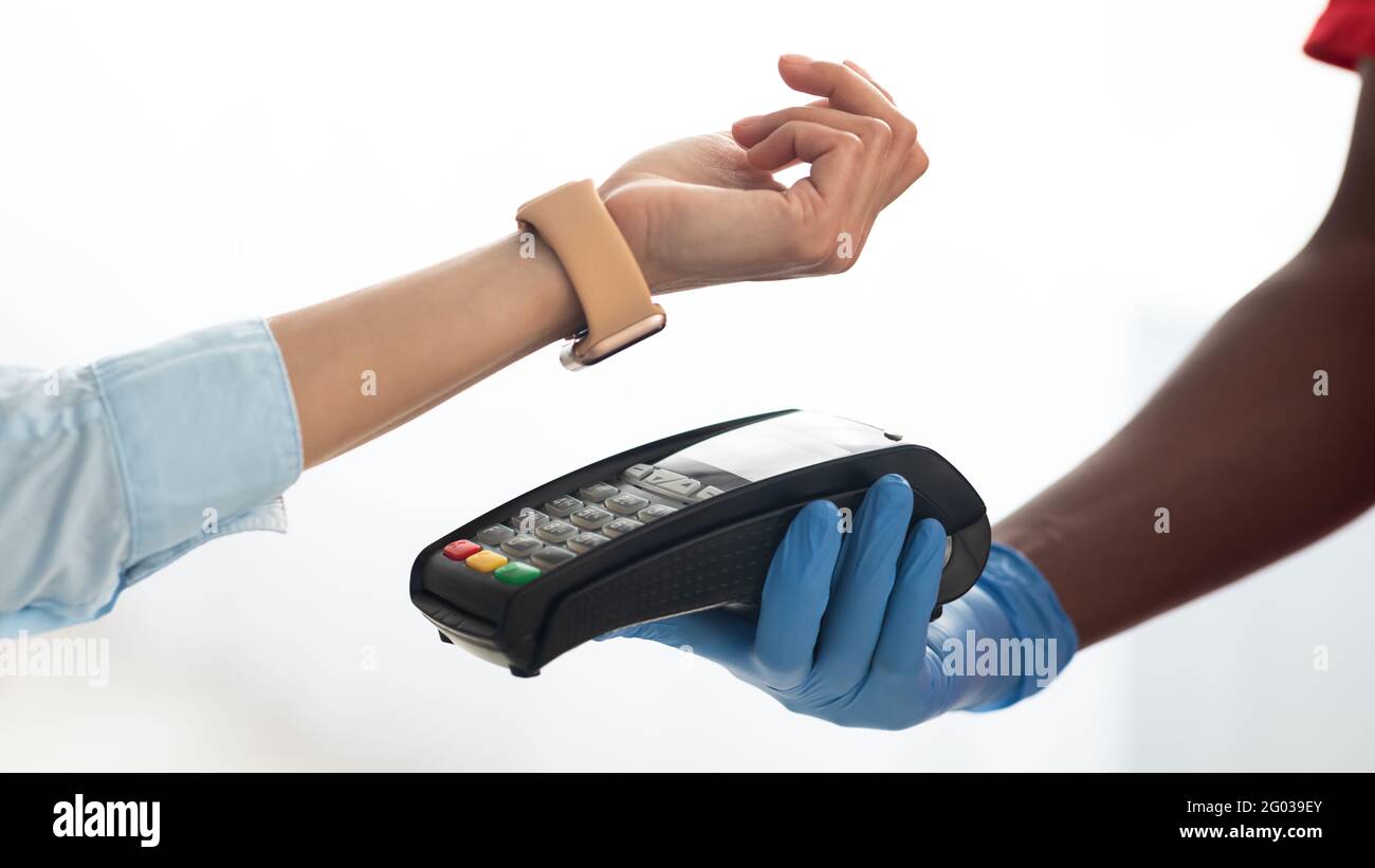 Black man holding POS machine woman paying with smart watch Stock Photo ...