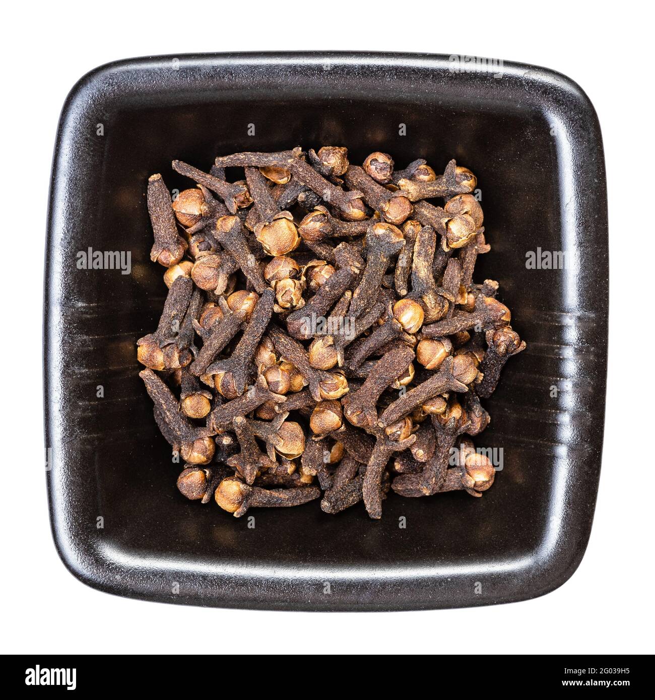 top view of whole dried cloves in black bowl isolated on white ...