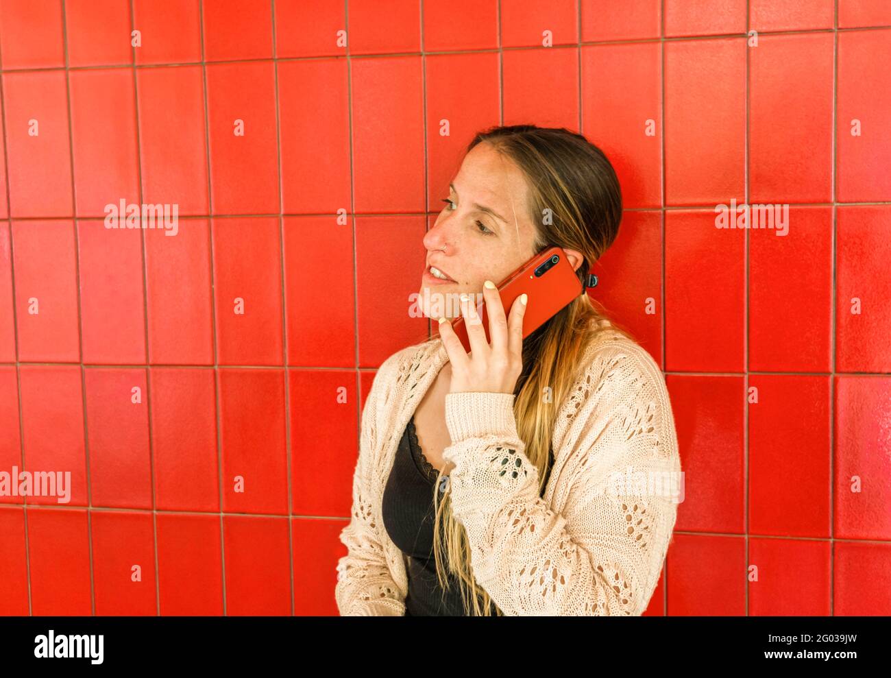 Woman talking on cell phone on red background.Female using phone ...