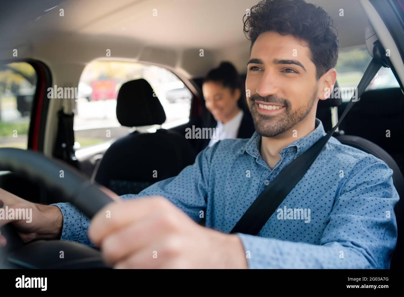 Taxi driver with passenger at back seat Stock Photo - Alamy