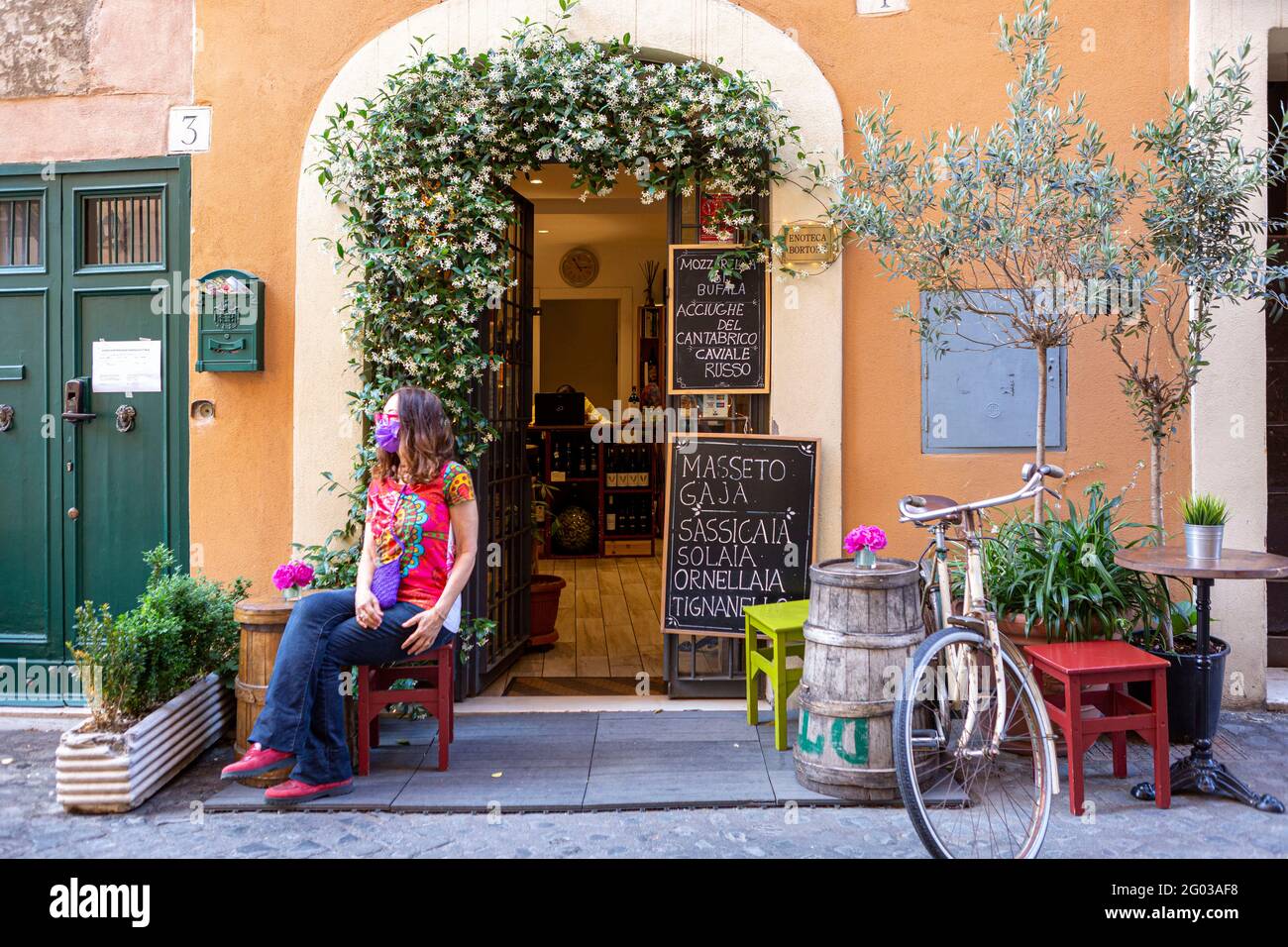 woman sitting outside shop in Rome historic centre Stock Photo - Alamy