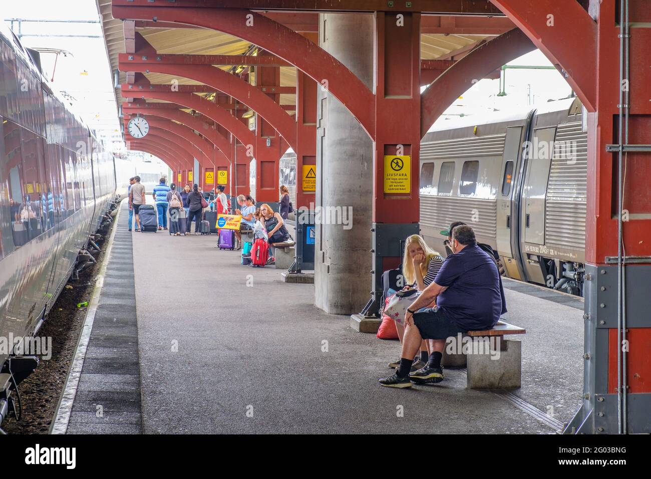 Train on a platform with waiting people Stock Photo - Alamy