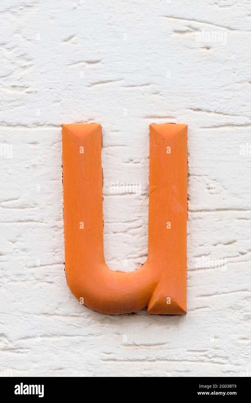 Orange letter u on a white house wall Stock Photo - Alamy