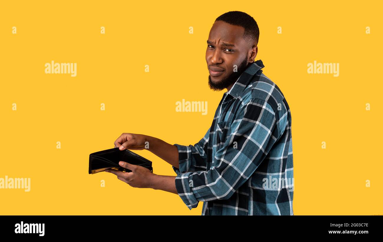 Poor African American Guy Showing Empty Wallet Over Yellow Background ...