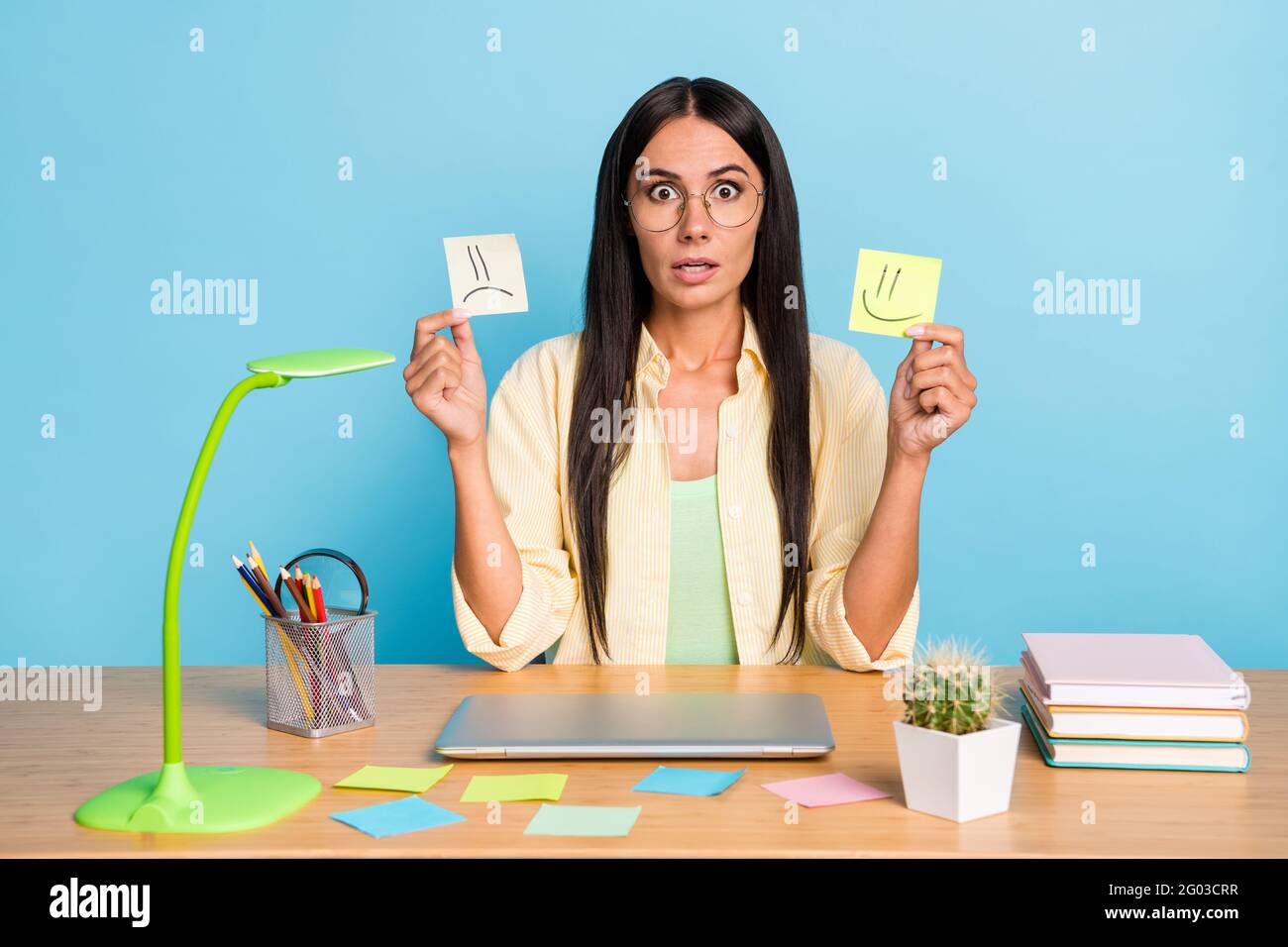 Portrait of attractive amazed girl preparing homework holding in hands ...