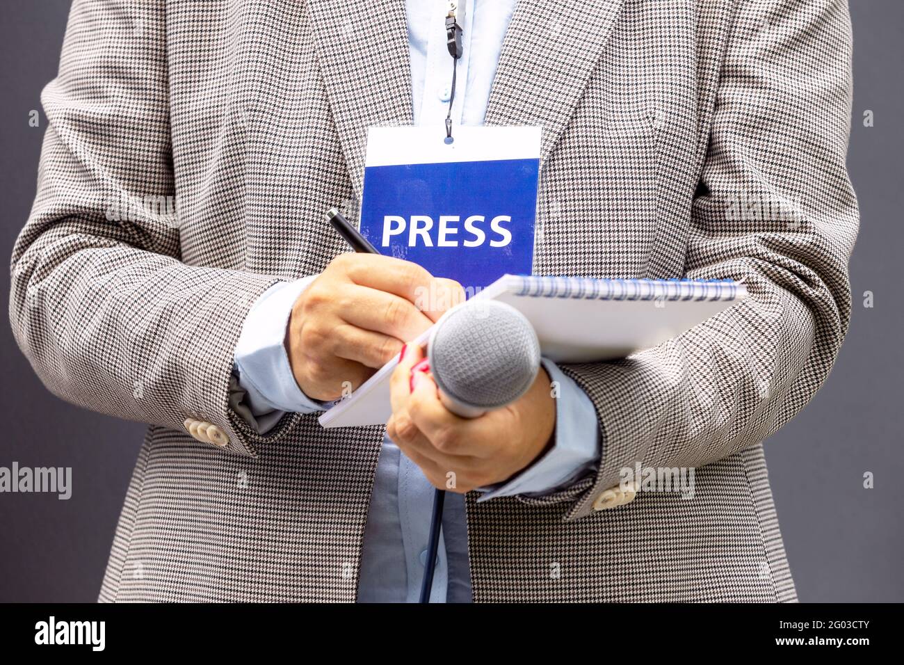 Female reporter at news conference or media event, writing notes ...