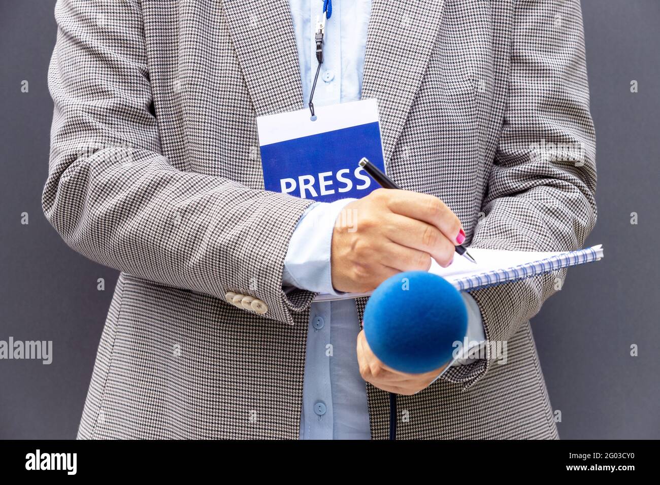 Female reporter at news conference or media event, writing notes ...