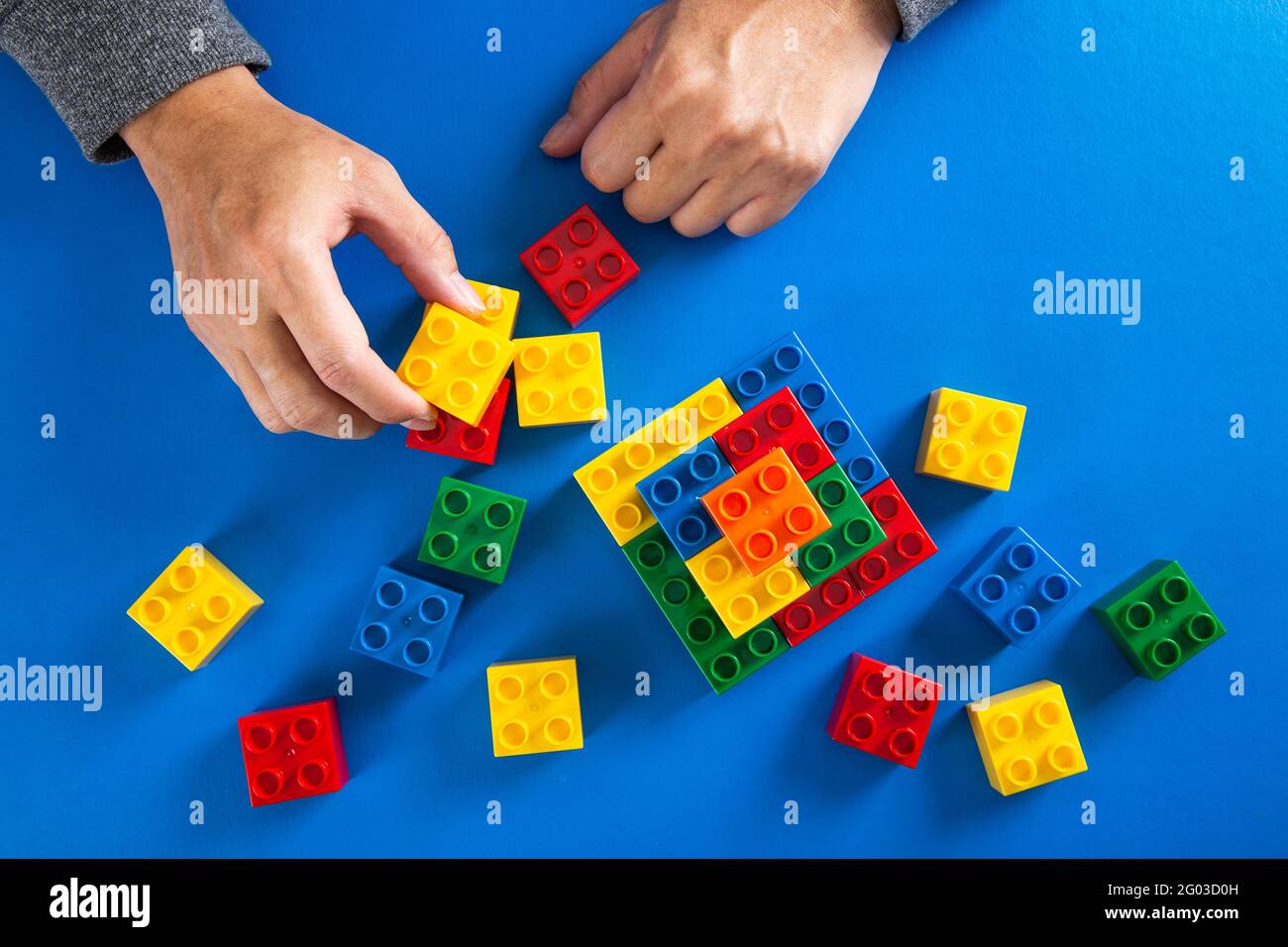 hand stacking up the colorful plastic block Stock Photo - Alamy