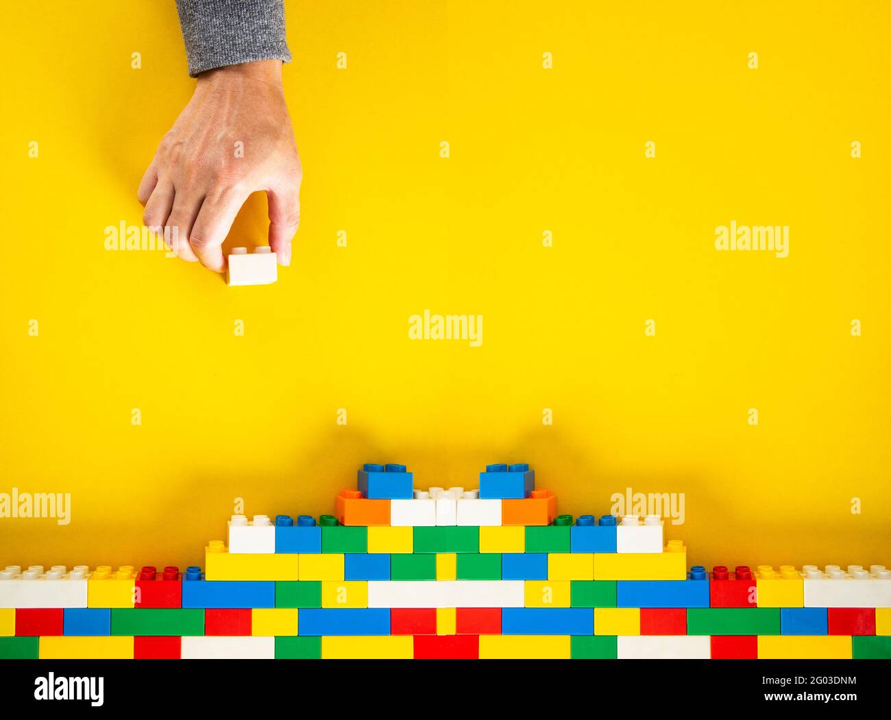 hand stacking up the colorful plastic block Stock Photo - Alamy