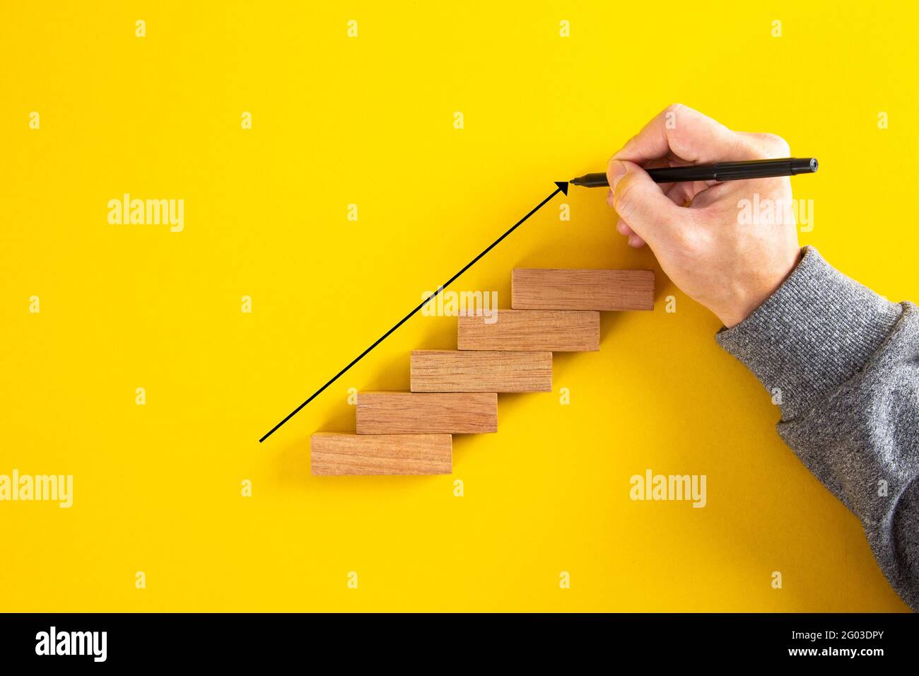 Man hand drawing an upward pointing arrow on top of growing graph made ...