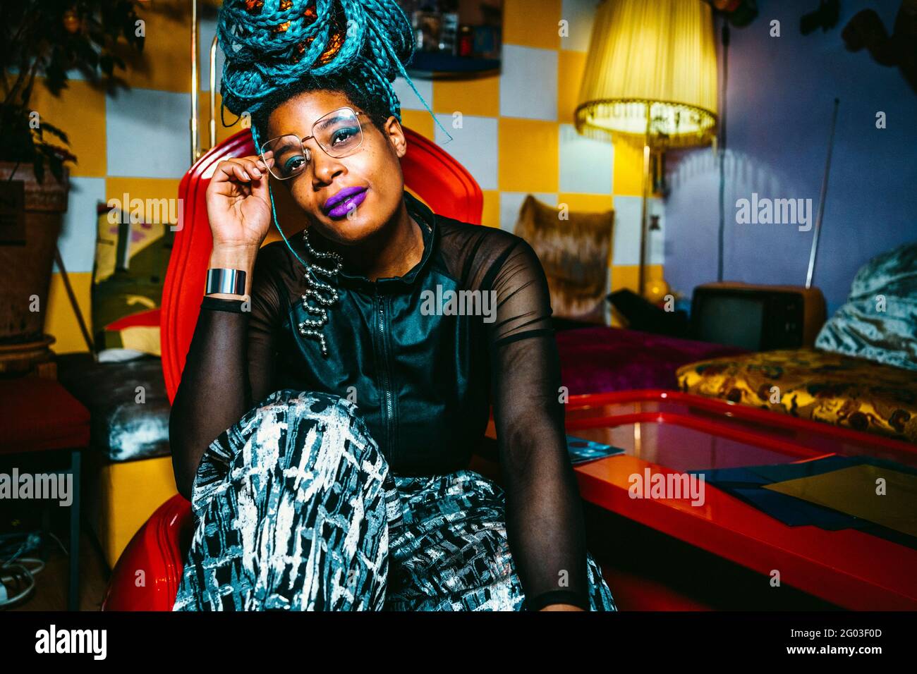 Portrait of woman sitting on chair holding her hair hi-res stock ...