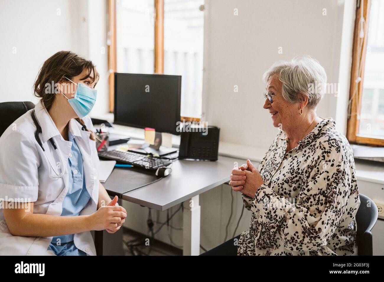 Doctor talking to patient wearing mask hi-res stock photography and ...