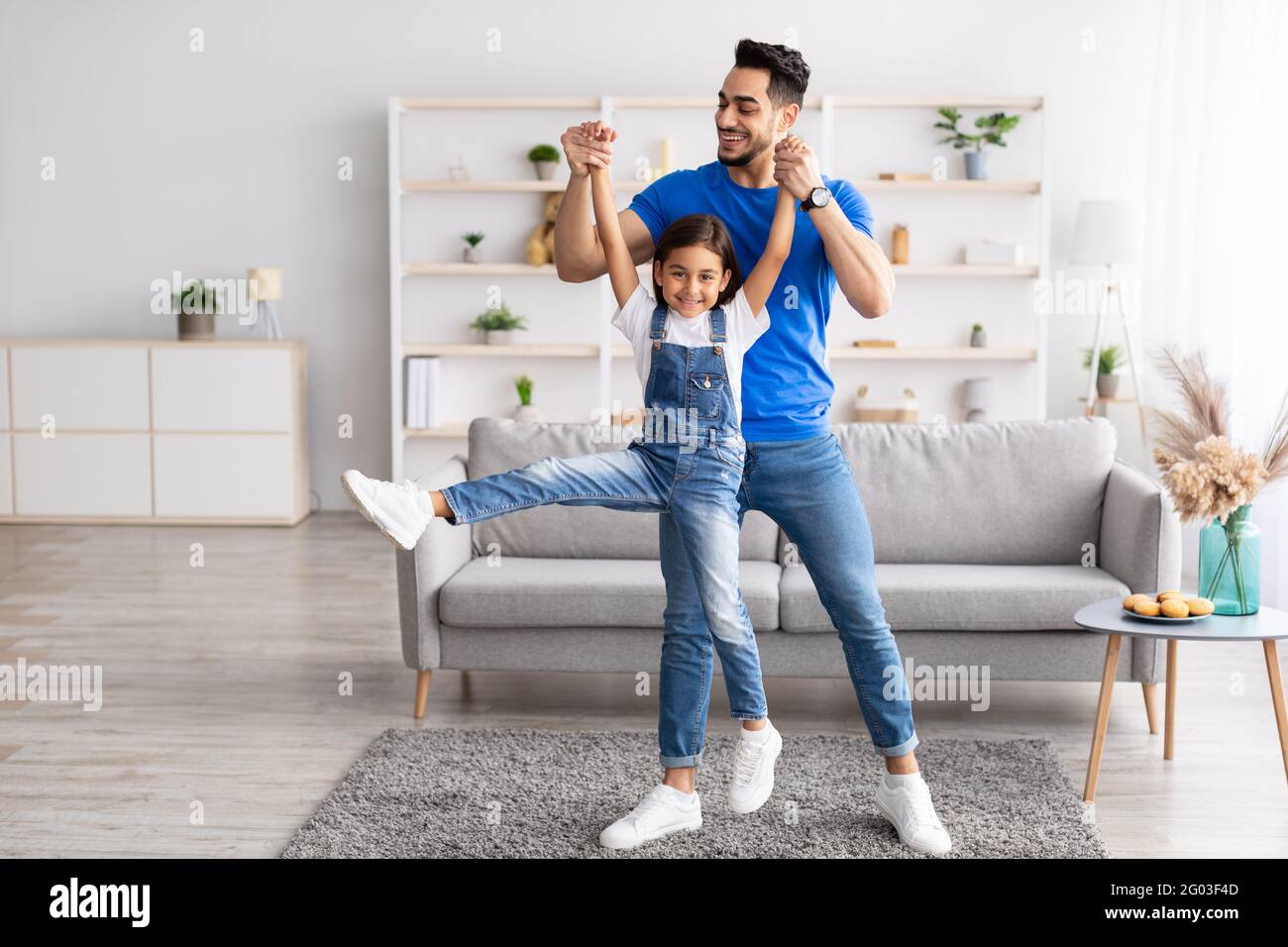 Dad and daughter dancing having fun in living room together Stock Photo ...