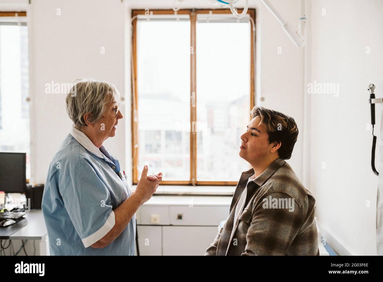 Senior medical expert discussing with male patient while consulting in ...