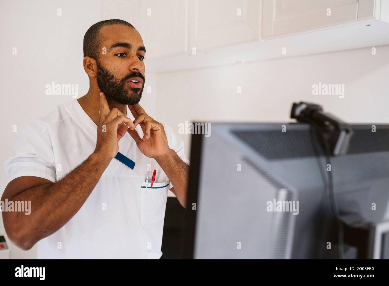 Male doctor consulting through video call at medical clinic Stock Photo ...