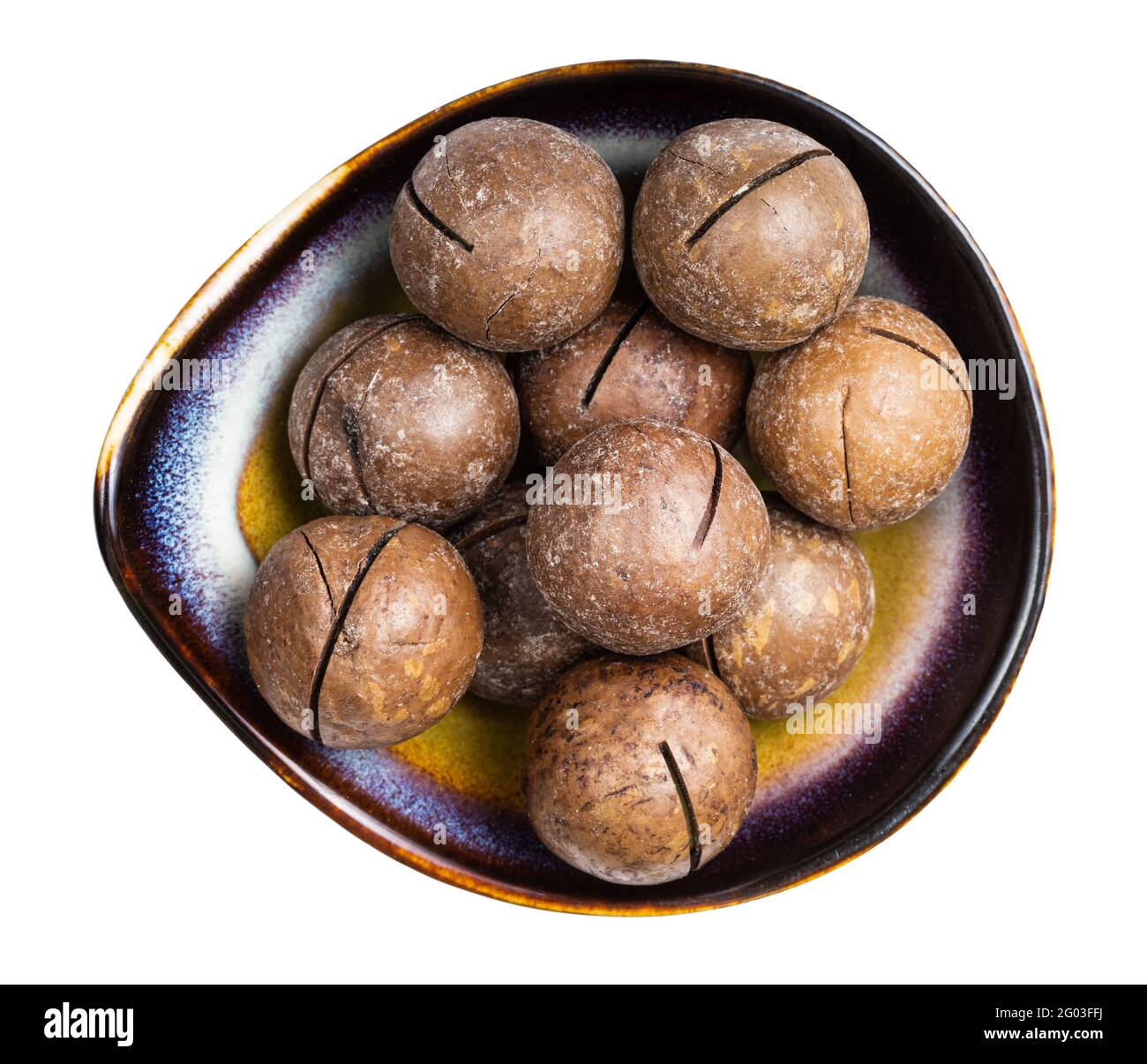 top view of sawn macadamia nuts in ceramic bowl isolated on white ...
