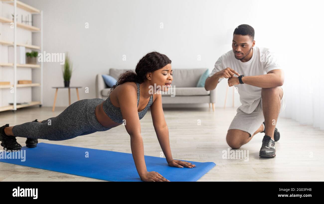 Young black lady having difficulty standing in plank for too long, her ...