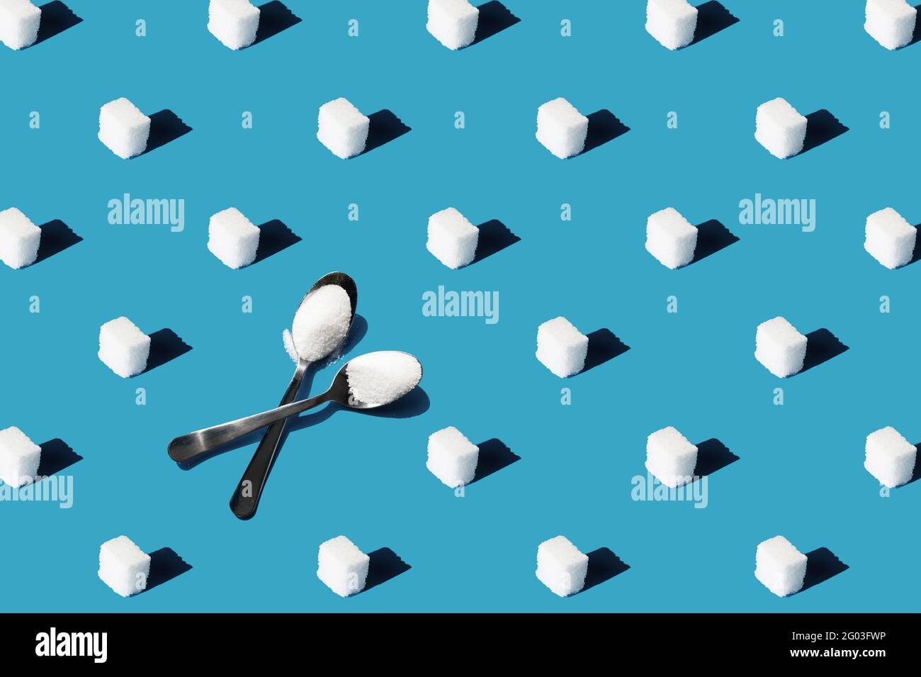 Refined sugar and spoons with white sugar pattern on a blue background ...
