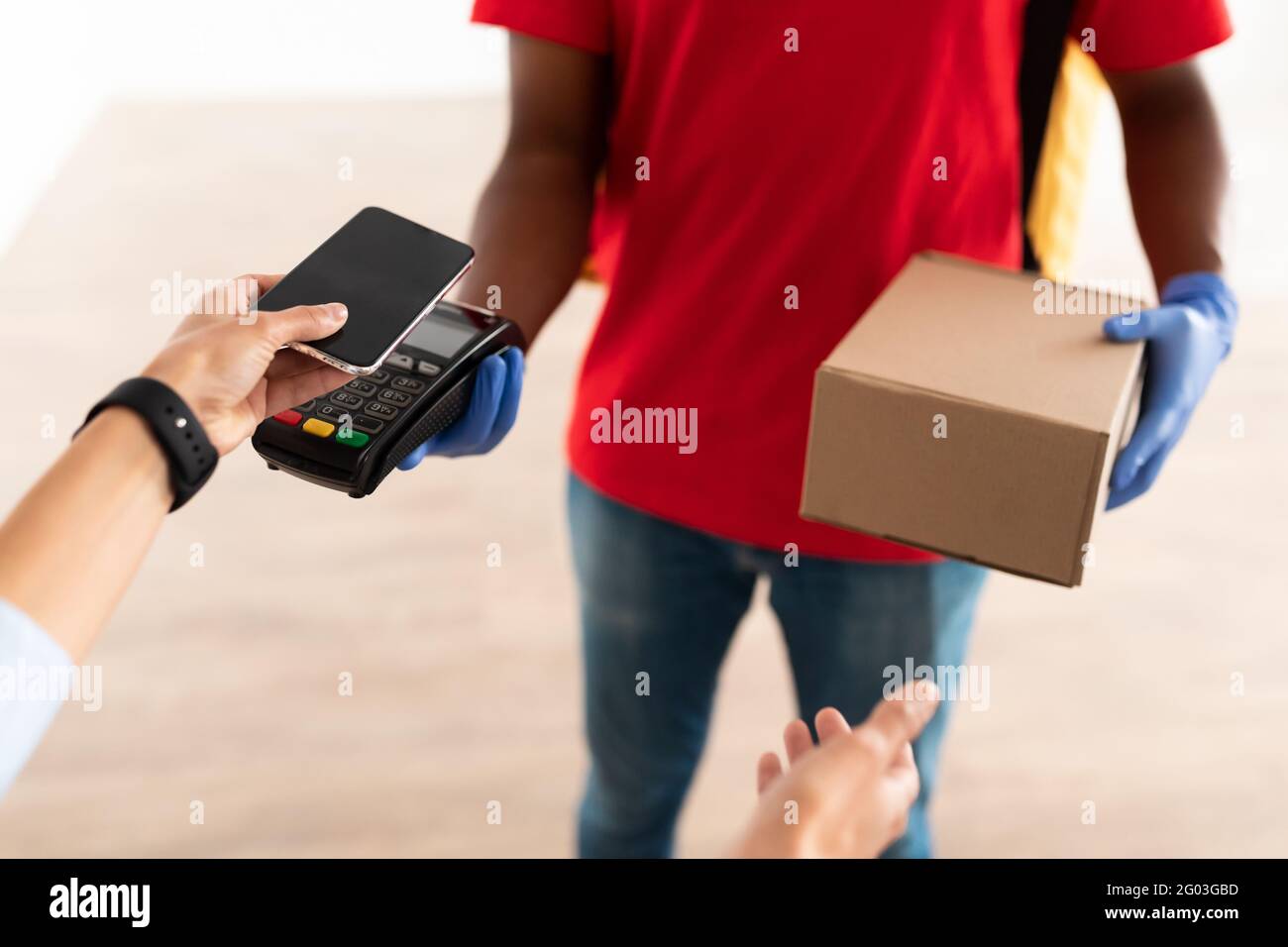 Black man holding POS machine client paying with smart phone Stock ...