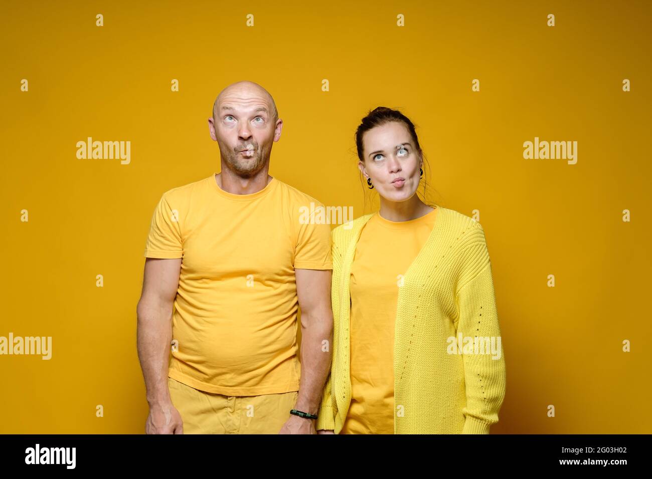 Strange man and woman in yellow robes, made stupid faces. Bright ...