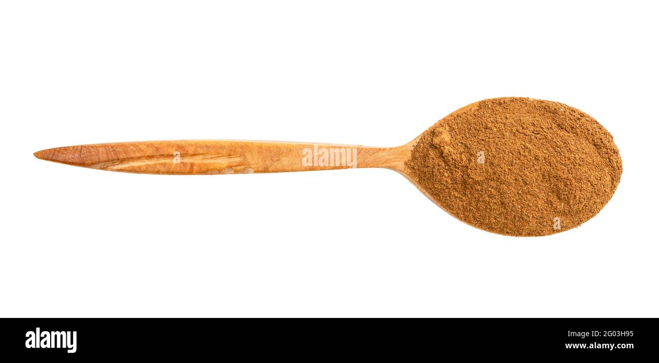top view of wood spoon with cinnamon powder isolated on white ...