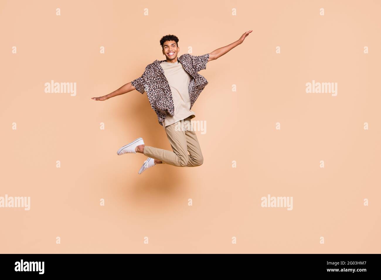 Full body portrait of excited dark skin guy jump high hands fly toothy ...