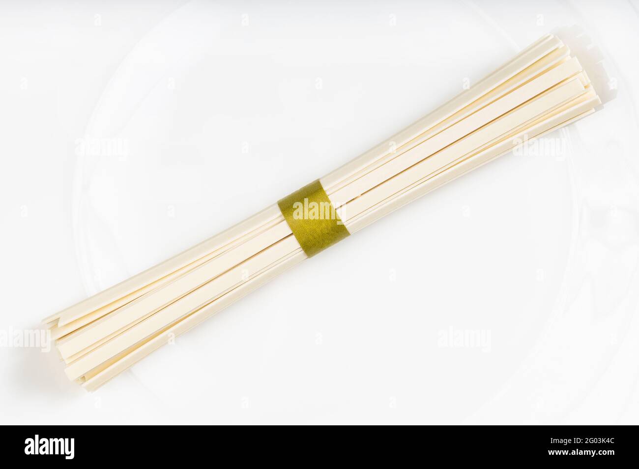 bunch of dried flat Udon noodles from wheat flour on white plate Stock ...