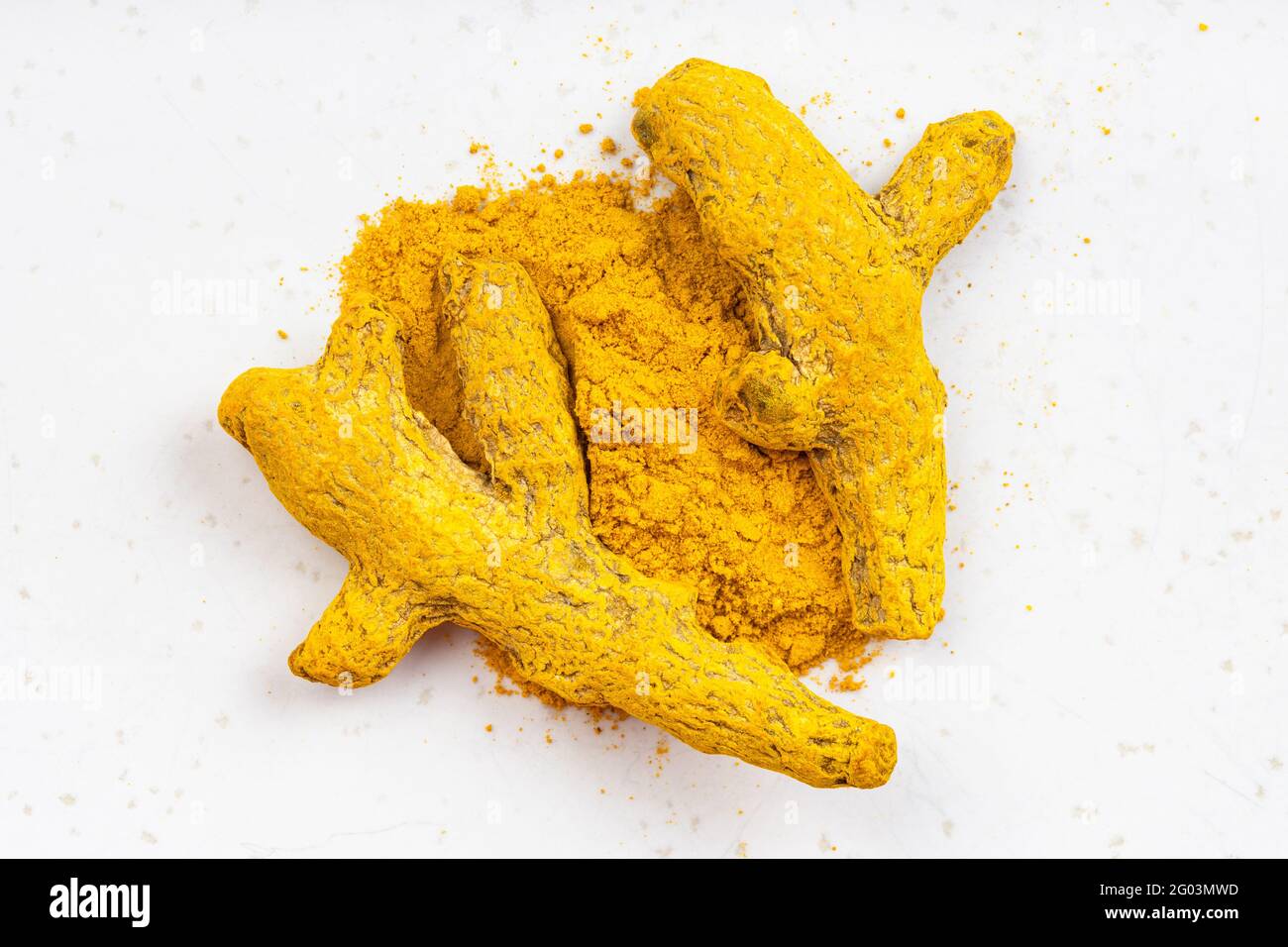 top view of pile of Turmeric (Curcuma) powder and roots close up on ...