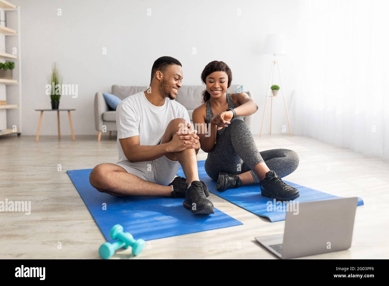Young black couple taking break from home training, watching video ...