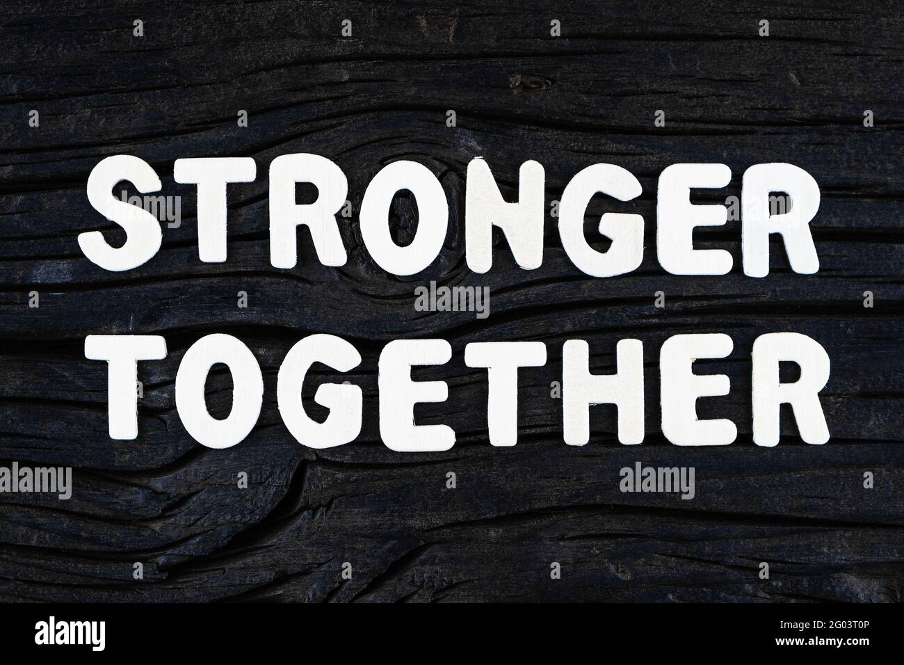 Stronger Together words on dark wooden background. Business ...