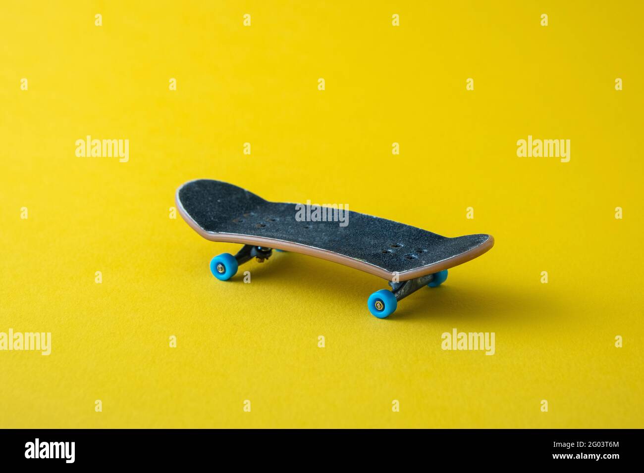 Mini skateboard on yellow background Stock Photo - Alamy