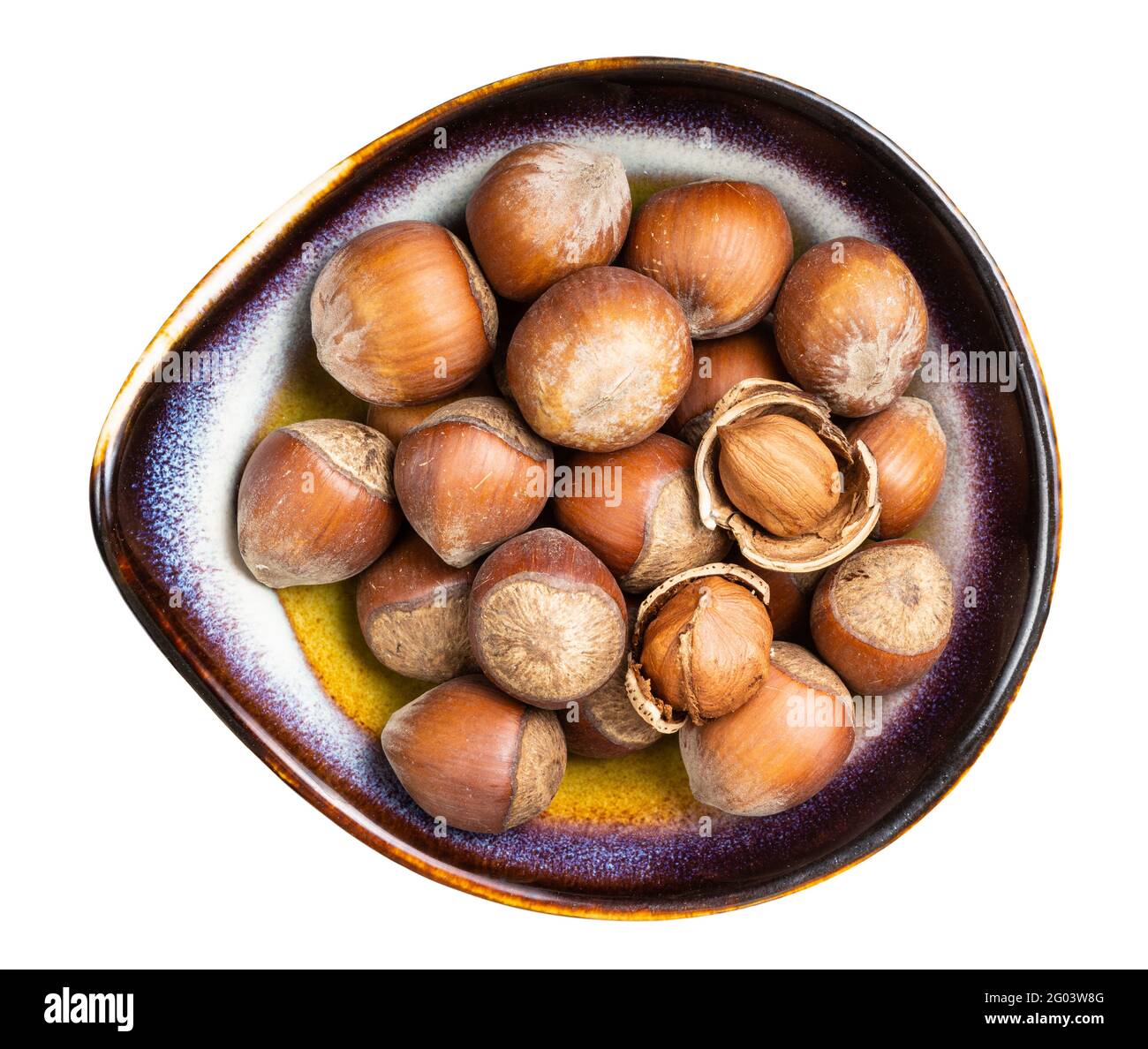 top view of shelled and whole hazelnuts in ceramic bowl isolated on ...