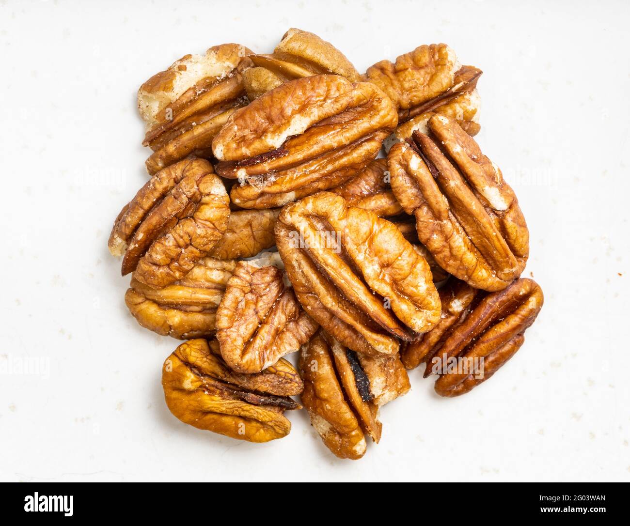top view of pile of shelled pecan nuts close up on gray ceramic plate ...
