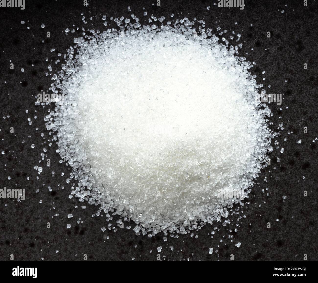 above view of pile of white refined beet sugar close up on black ...