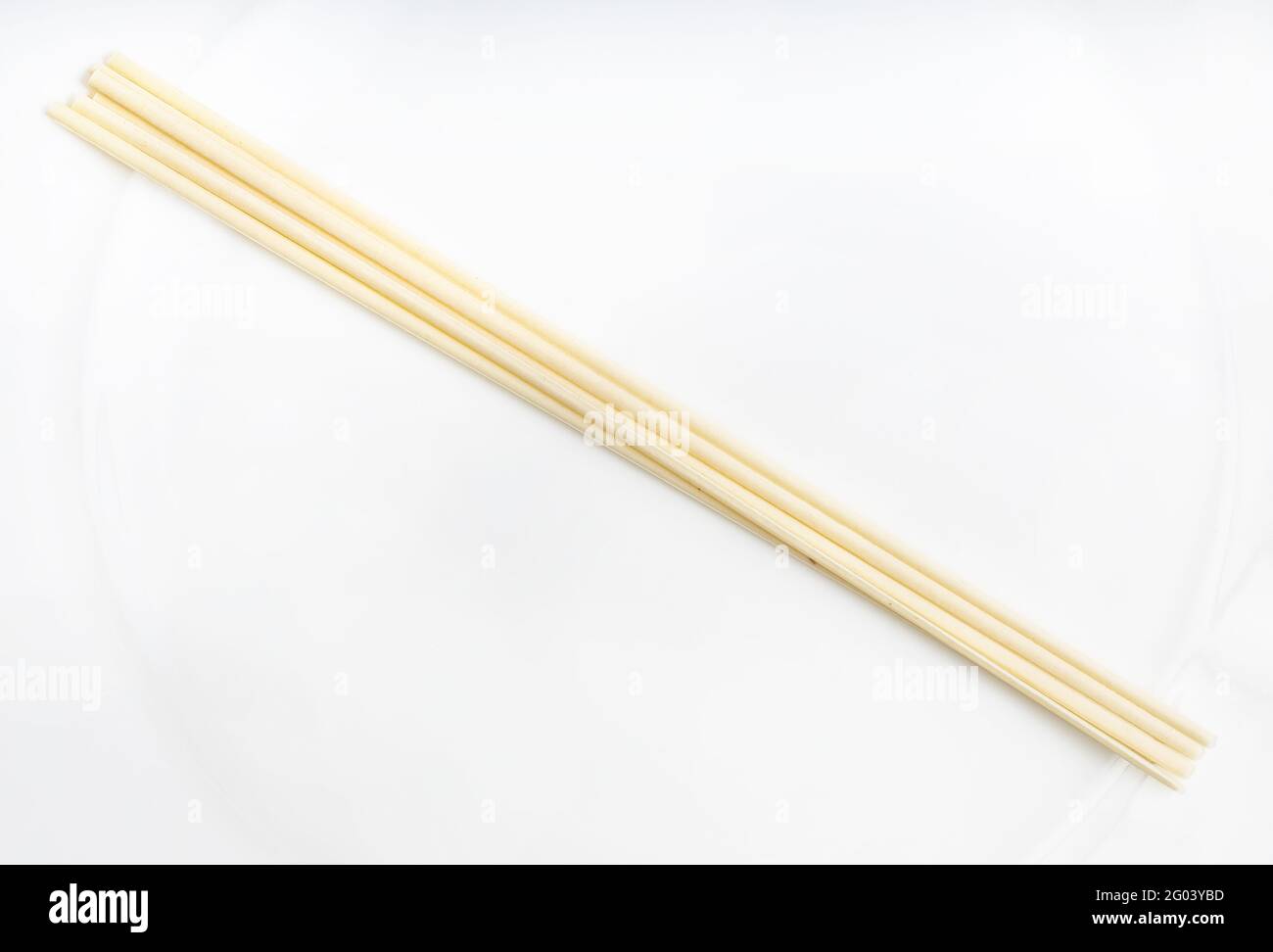 several dried round Udon noodles from wheat flour on white plate Stock ...