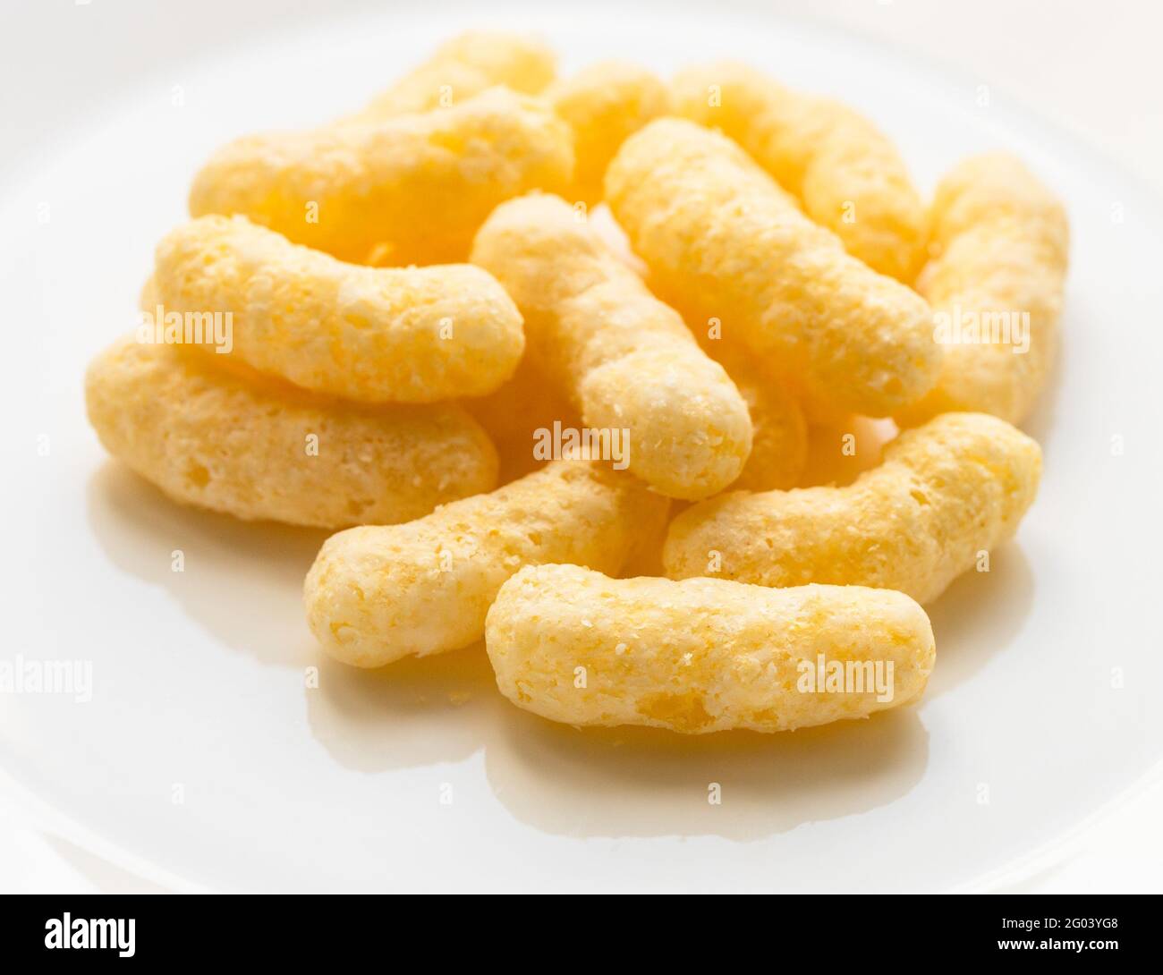 pile of corn puffs on white plate cllose up Stock Photo - Alamy