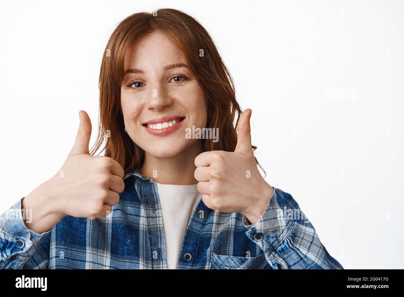 Close up portrait of beautiful ginger girl shows thumbs up, smiles ...