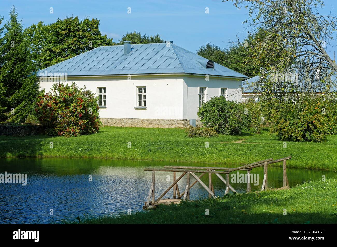 Stone house with white walls and a blue roof stands on the banks of a ...