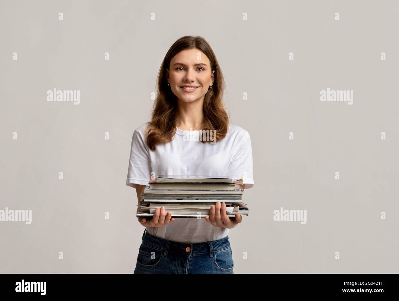 Waste Sorting. Portrait Of Beautiful Young Woman Holding Stack Of Old ...