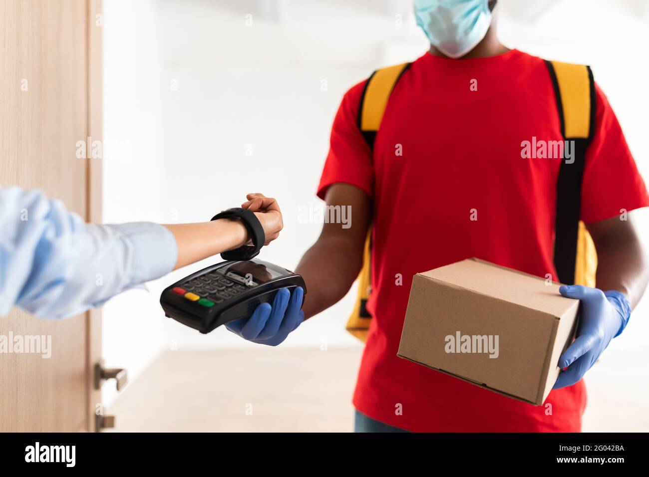 Black man holding POS machine client paying with smart watch Stock ...