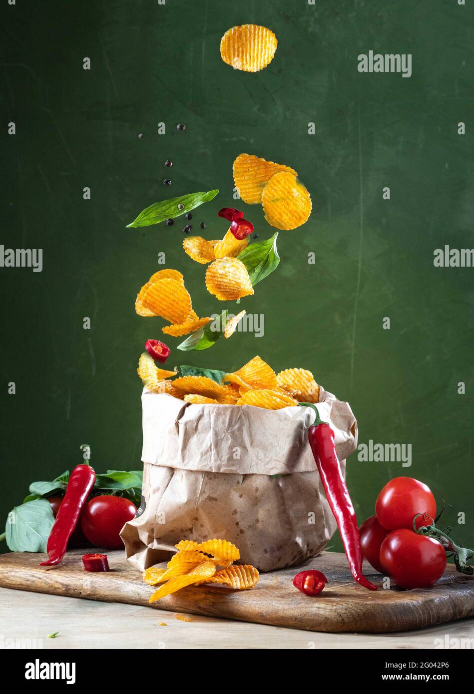 Potato chips fall into a paper bag. Spicy chips in a craft bag. Flying ...