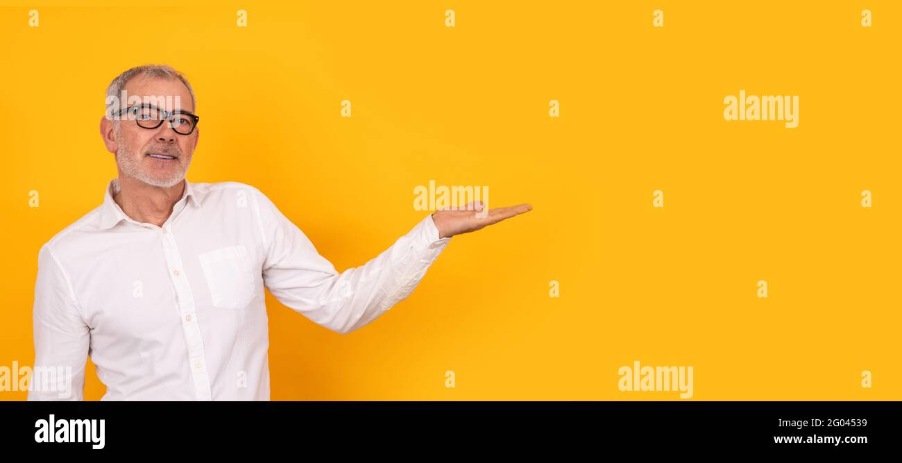 senior adult man pointing open hand at space Stock Photo - Alamy