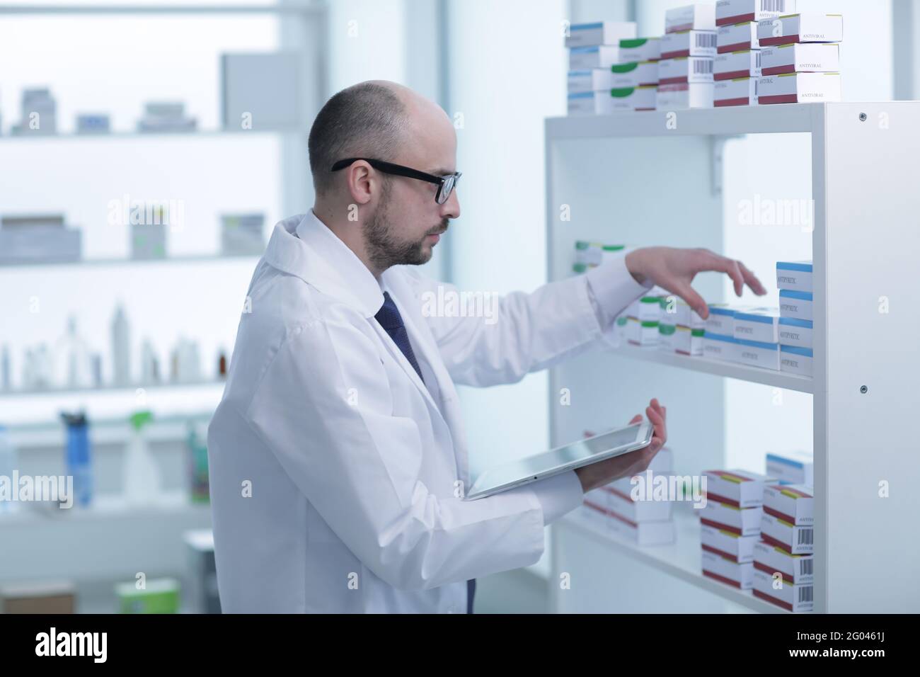 Pharmacist is working. Man wearing special uniform located in pharmacy ...