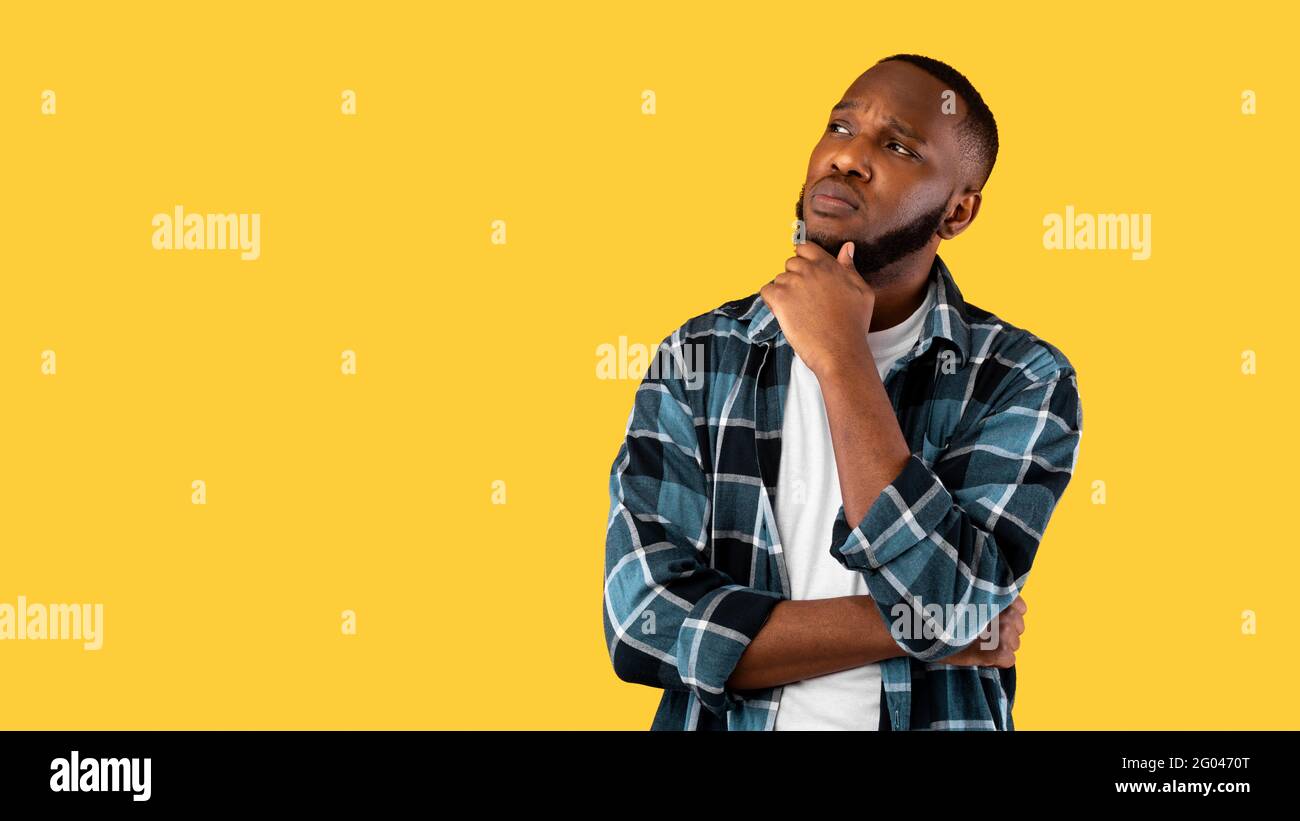 Thoughtful Black Guy Thinking Touching Chin Looking Aside, Yellow ... Thoughtful Black Guy Thinking Touching Chin Looking Aside, Yellow ...