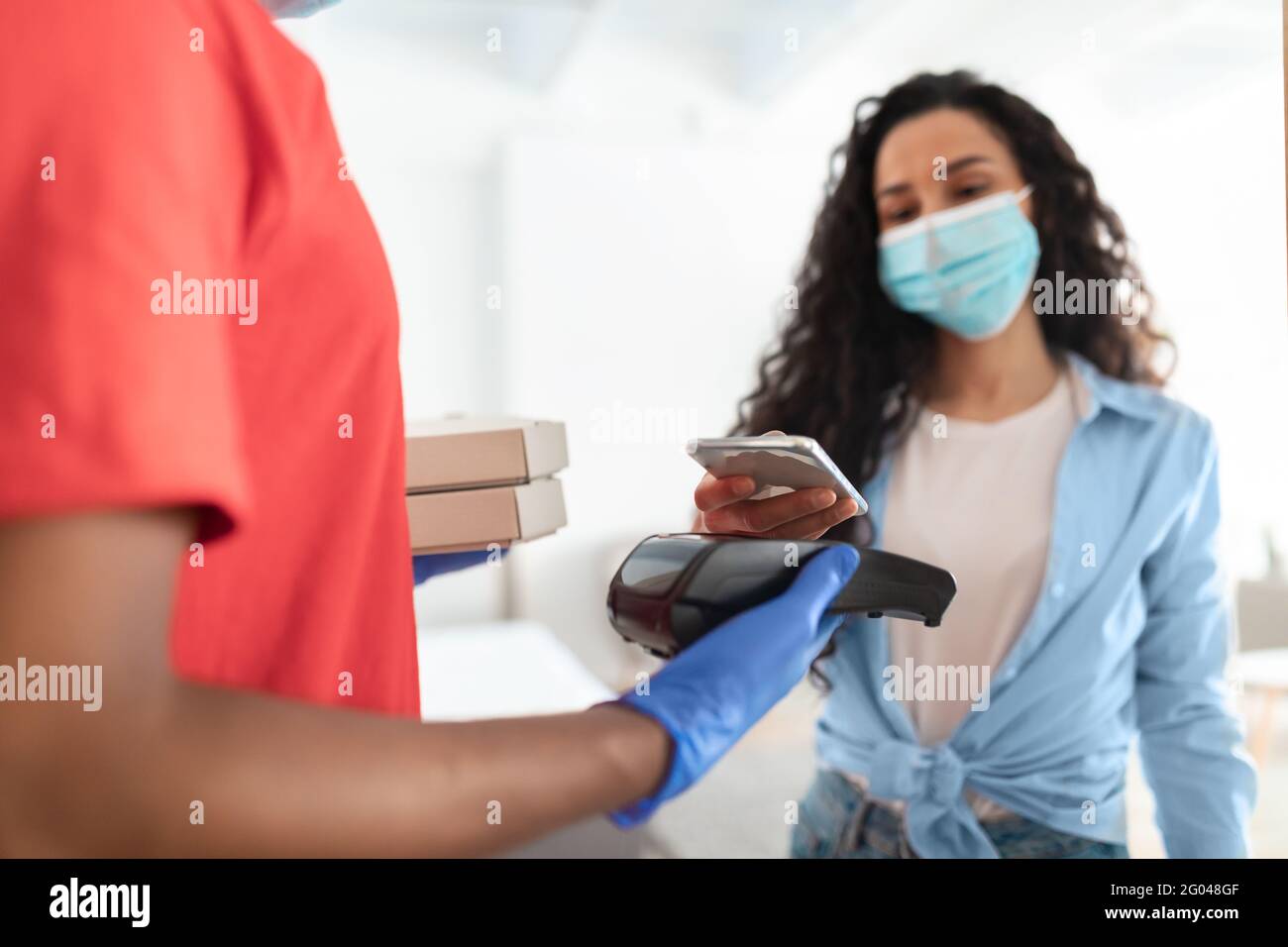 Black man holding POS machine client paying with smartphone Stock Photo ...
