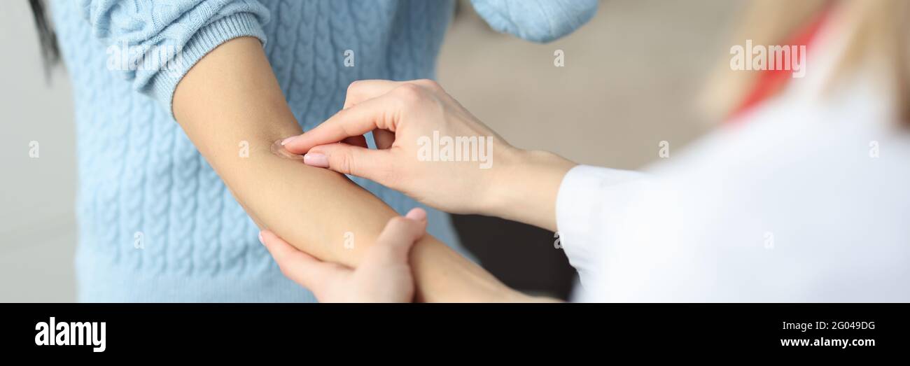 Doctor putting patch on patients forearm in clinic closeup Stock Photo ...