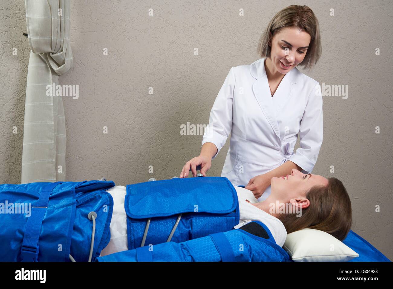 woman receiving the procedure of pressure therapy to make her legs ...